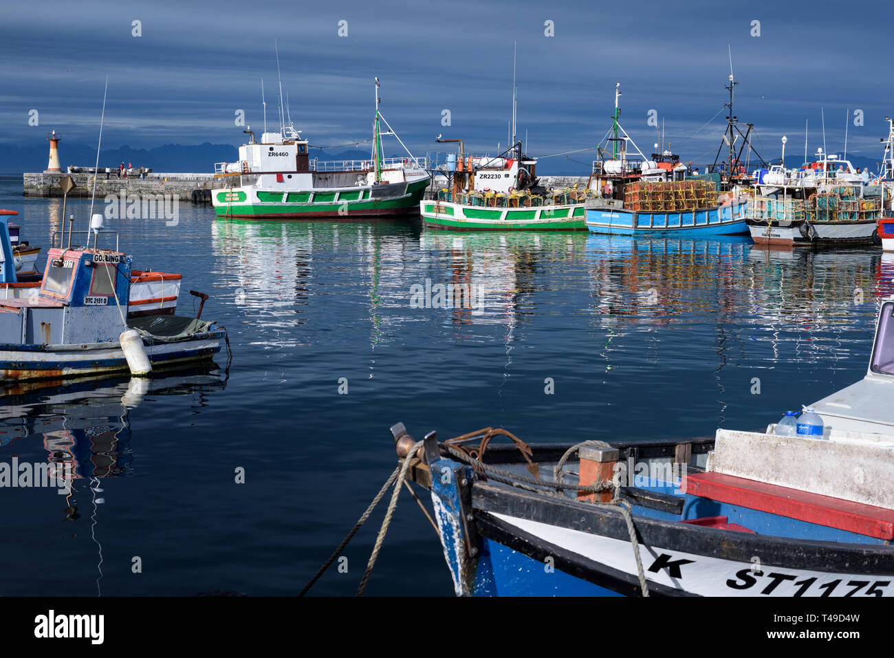 Fishing boats moored in Kalk Bay harbour on the False Bay coast line in ...