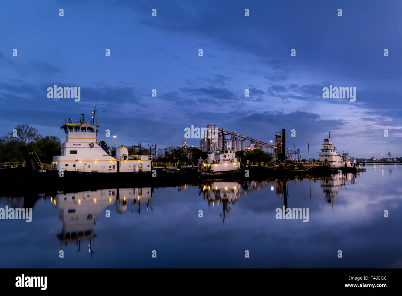 Tug boats on the Elizabeth River in Virginia after sunset, reflections ...