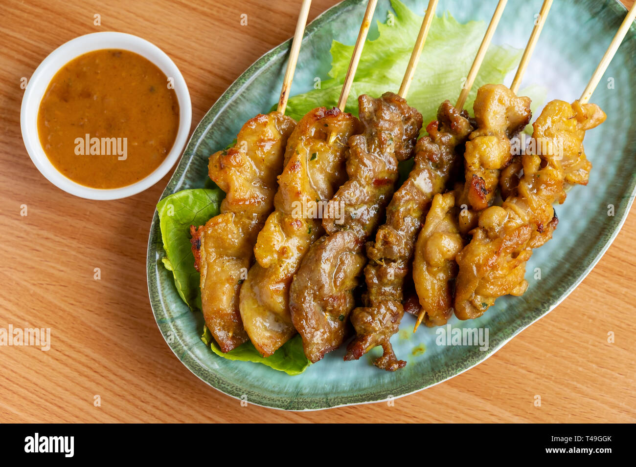 Six pieces of satay on a wood table Stock Photo - Alamy