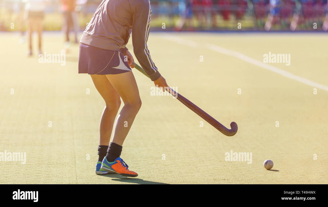 Young female field hockey player leading ball in attack. Image with ...