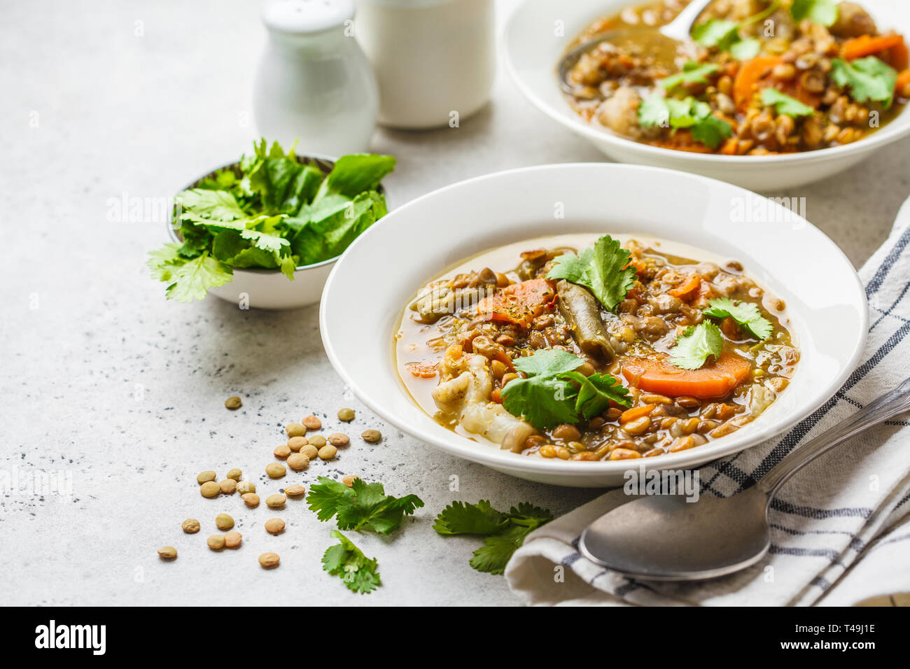 Lentil soup with vegetables in a white plate, white background. Plant ...