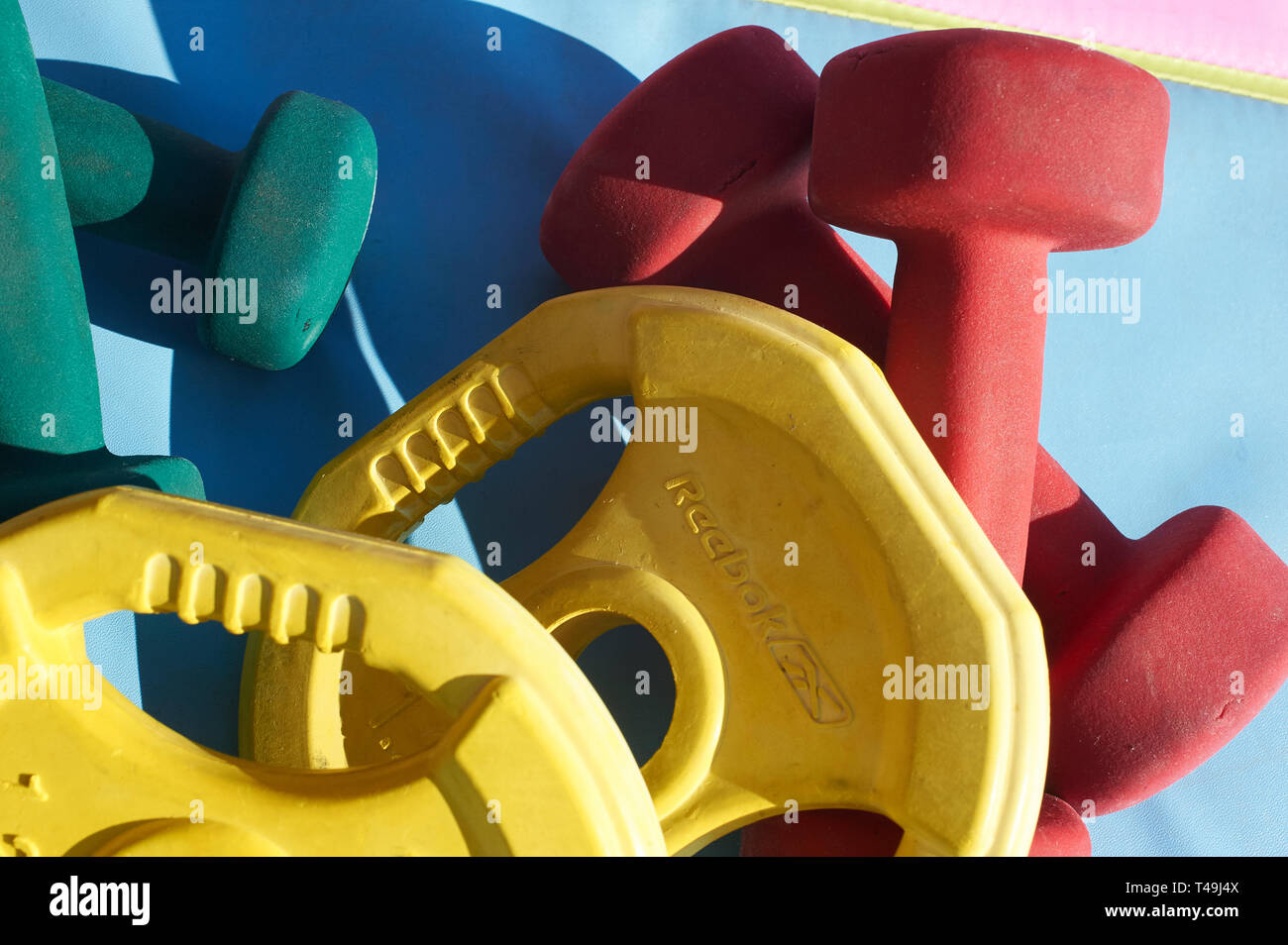 A selection of home gym equipment on a colourful yoga mat Stock Photo ...