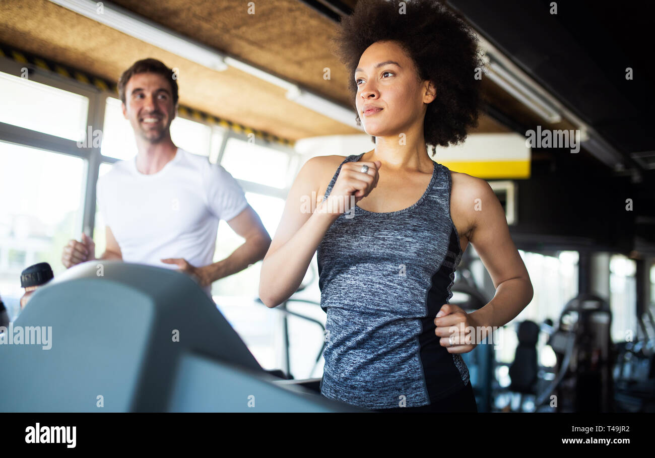 Happy fit people running on treadmill at fitness gym club Stock Photo ...