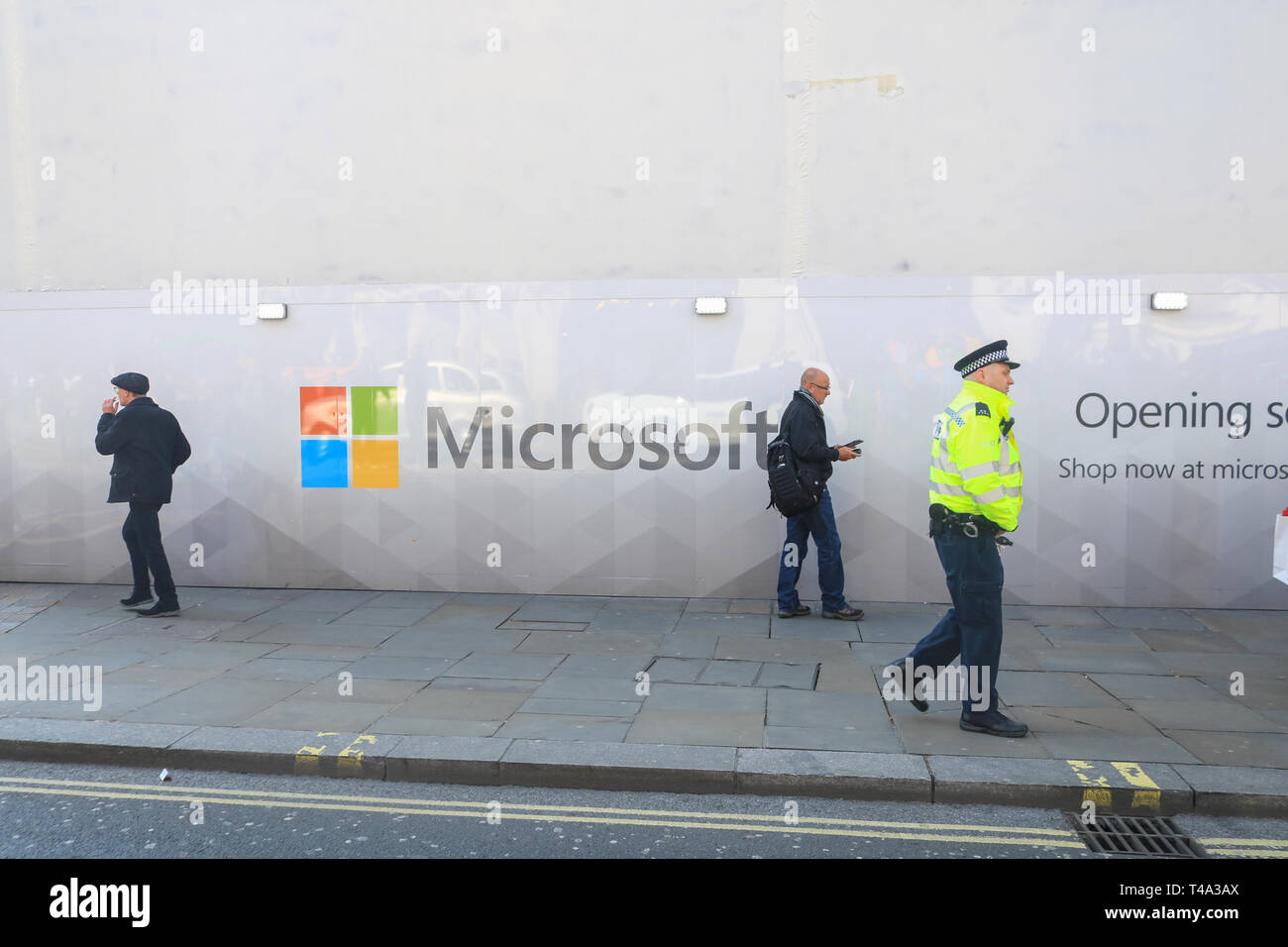 London, UK. 15th Apr, 2019. Pedestrians walk past a wall with the logo ...