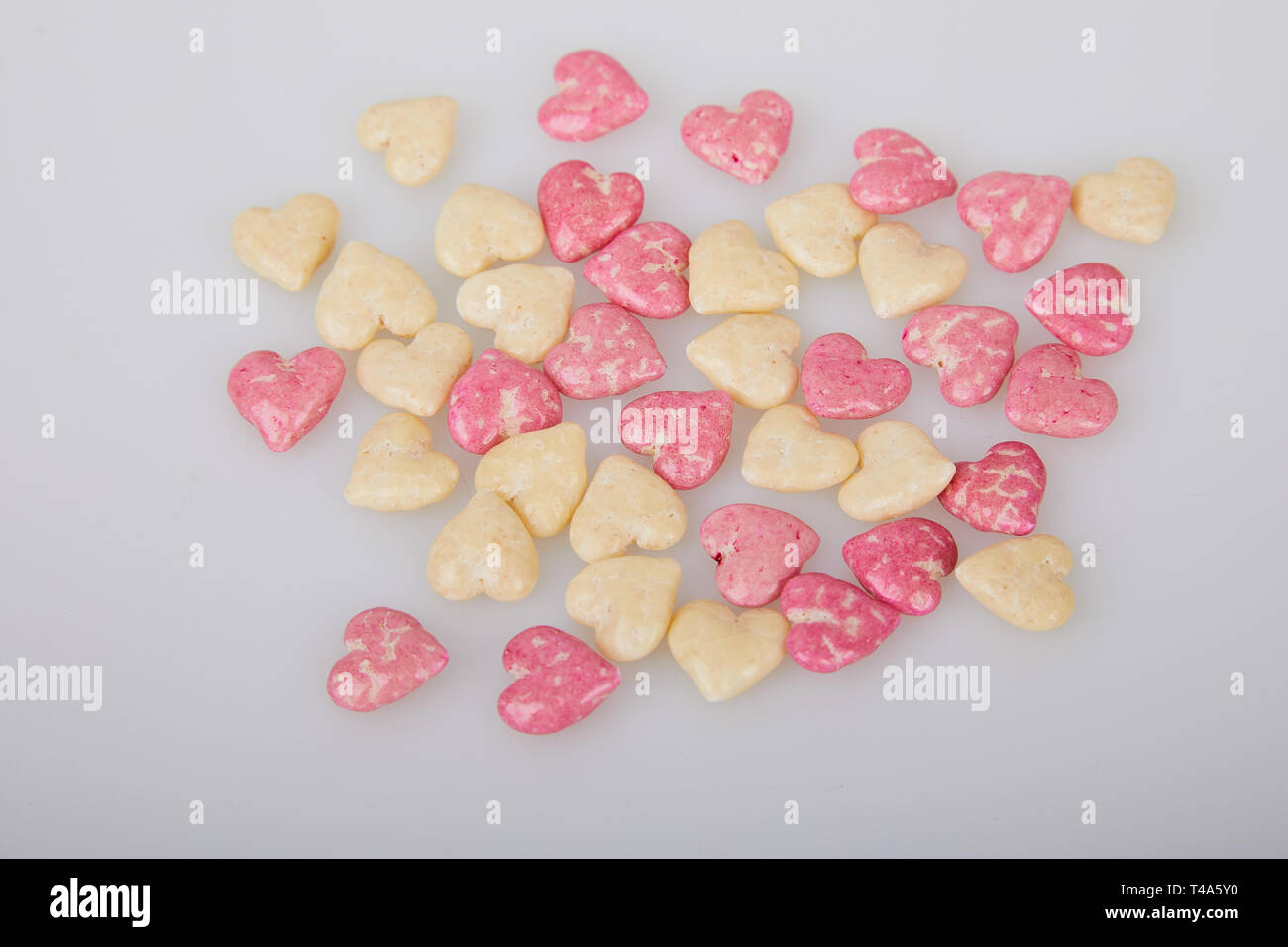 Mix of glazed, dry, pink and white heart shaped cereals breakfast on ...