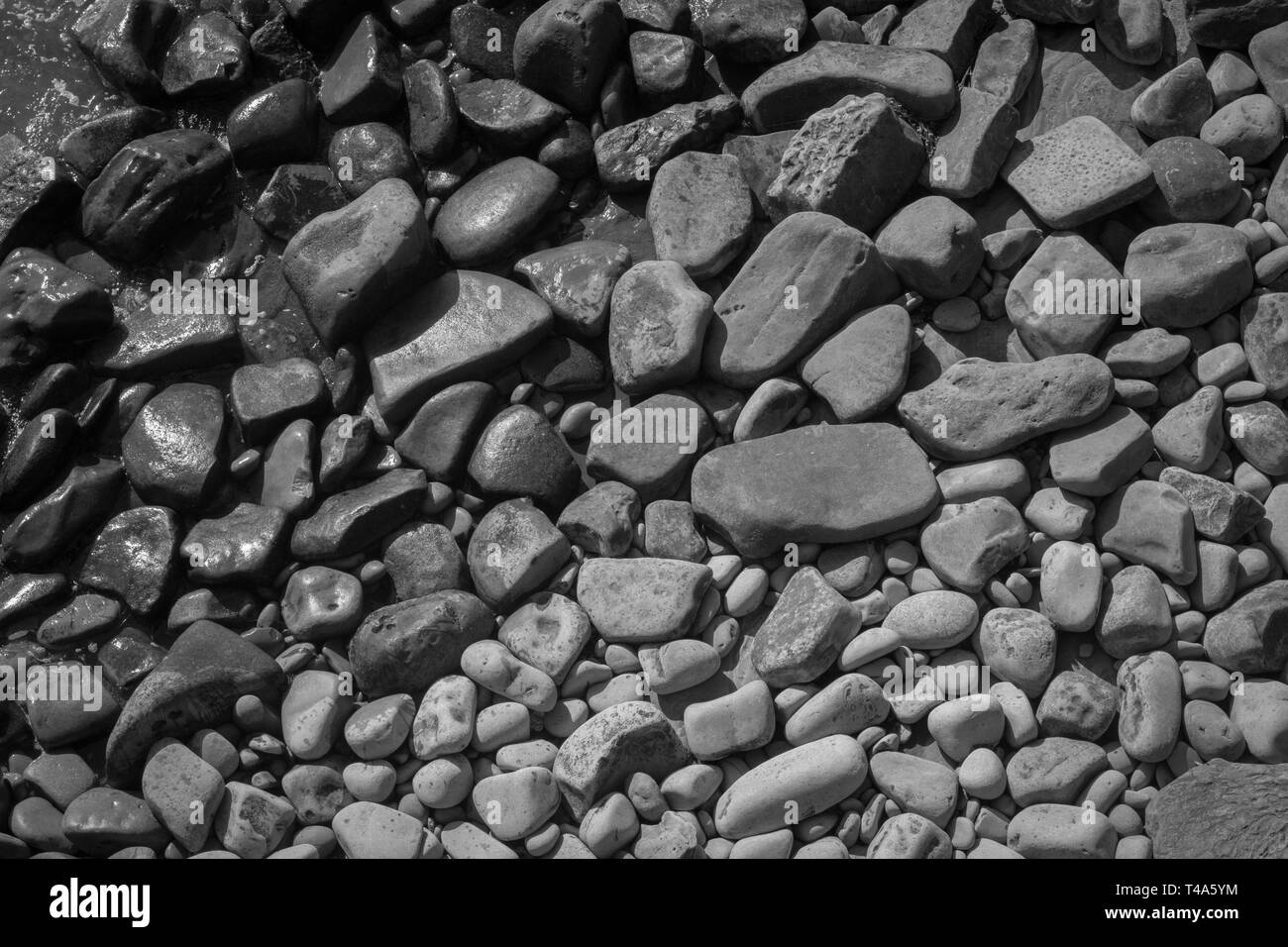 black and white rocks in the ocean textured background Stock Photo - Alamy