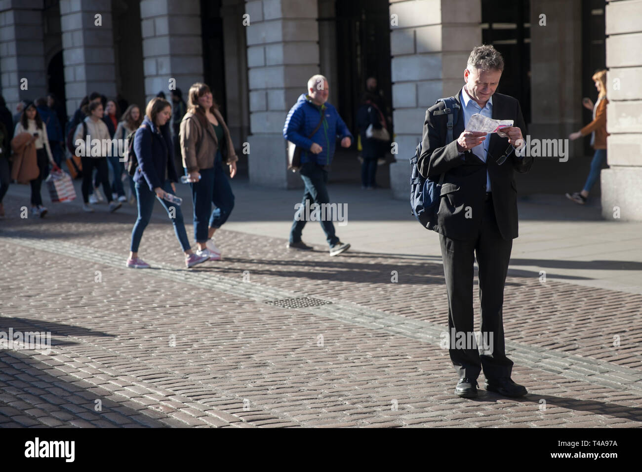 LONDON - FEBRUARY 17, 2019: A man in an office suit is considering a ...