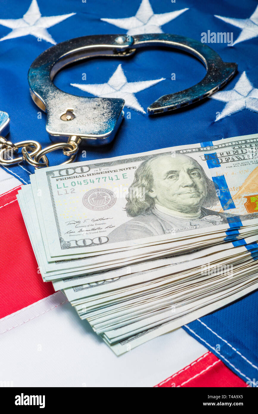 heap of money and handcuffs on american flag close up concept photo ...