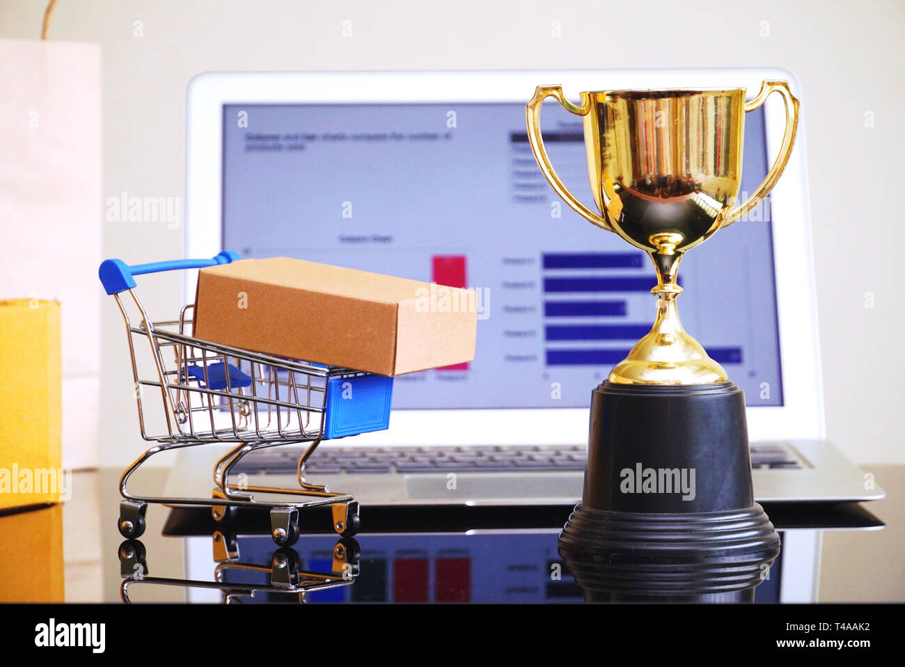 Trophy and packaging box on shopping cart with background computer ...