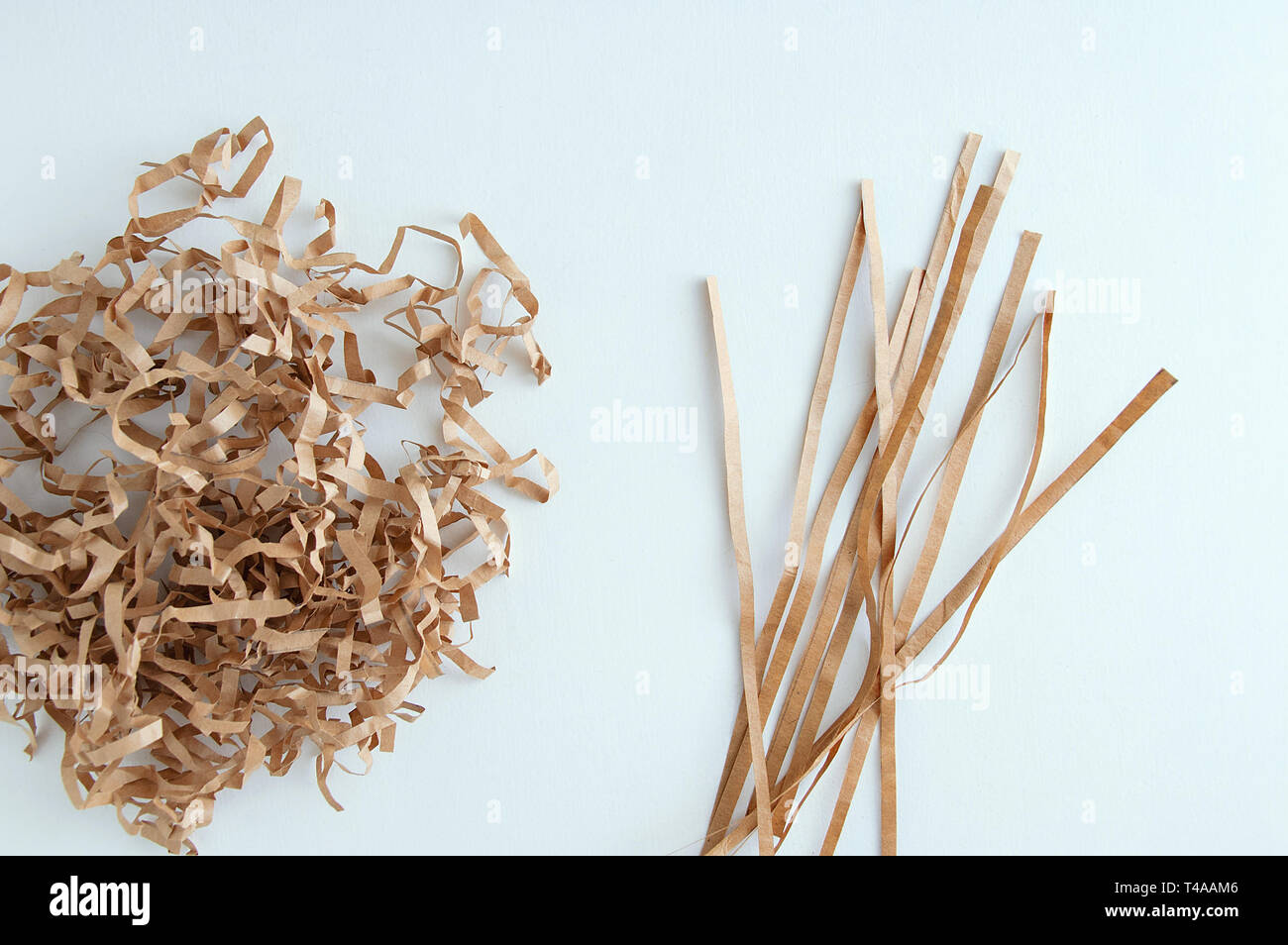 Brown paper cut into strips. View from above. White background. Paper ...