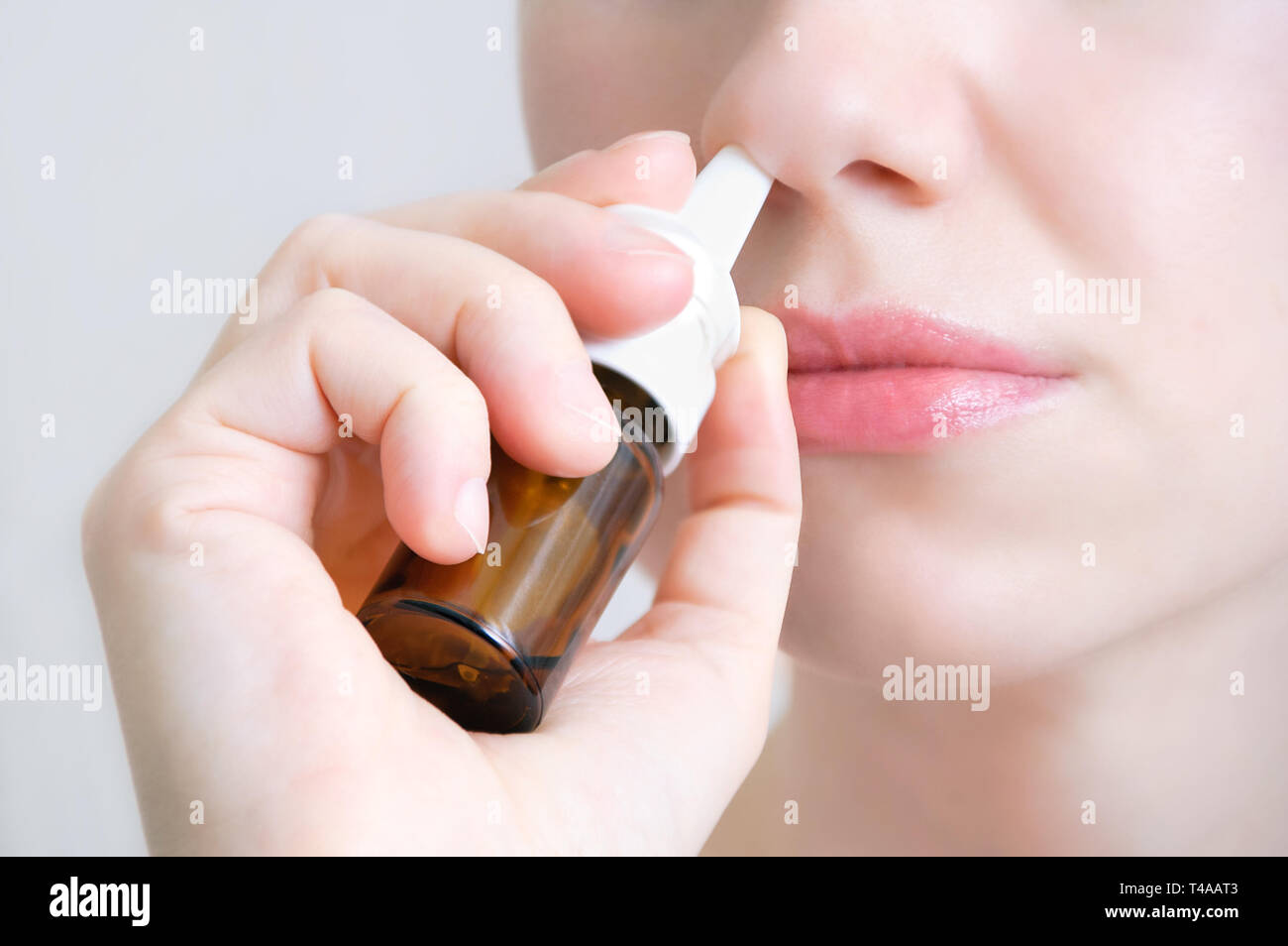 Nasal spray. Beautiful young woman. Closeup. Face with nasal drops ...
