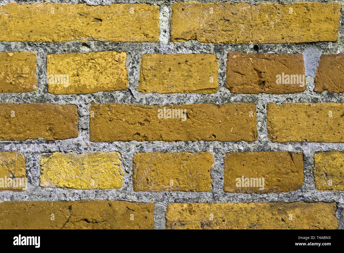 Weathered and aged yellow brick walls with cracks in high resolution ...