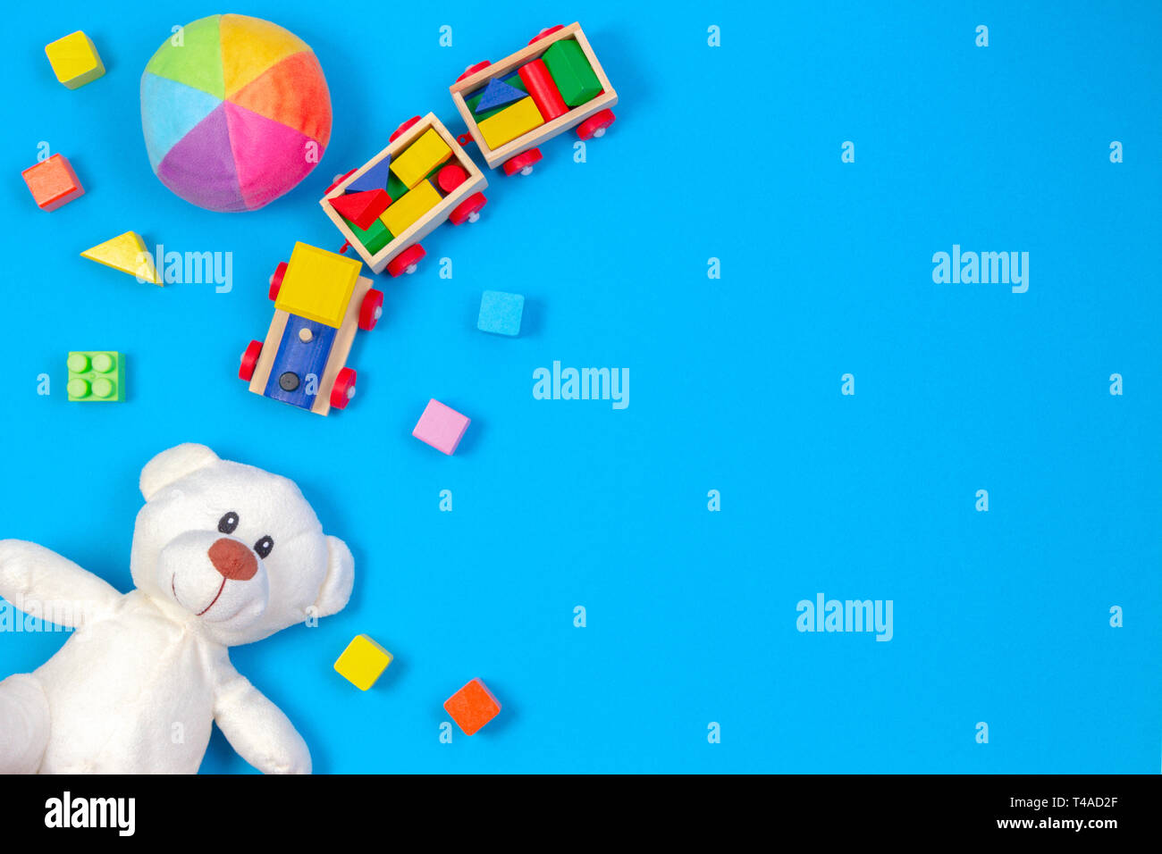 Baby kids toys background. White teddy bear, wooden train, colorful ...