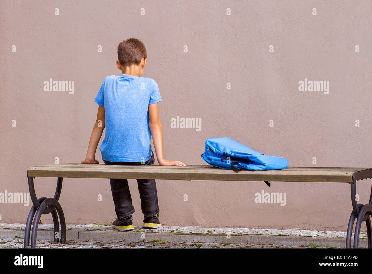 Sad alone child sitting on the bench outdoors Stock Photo - Alamy