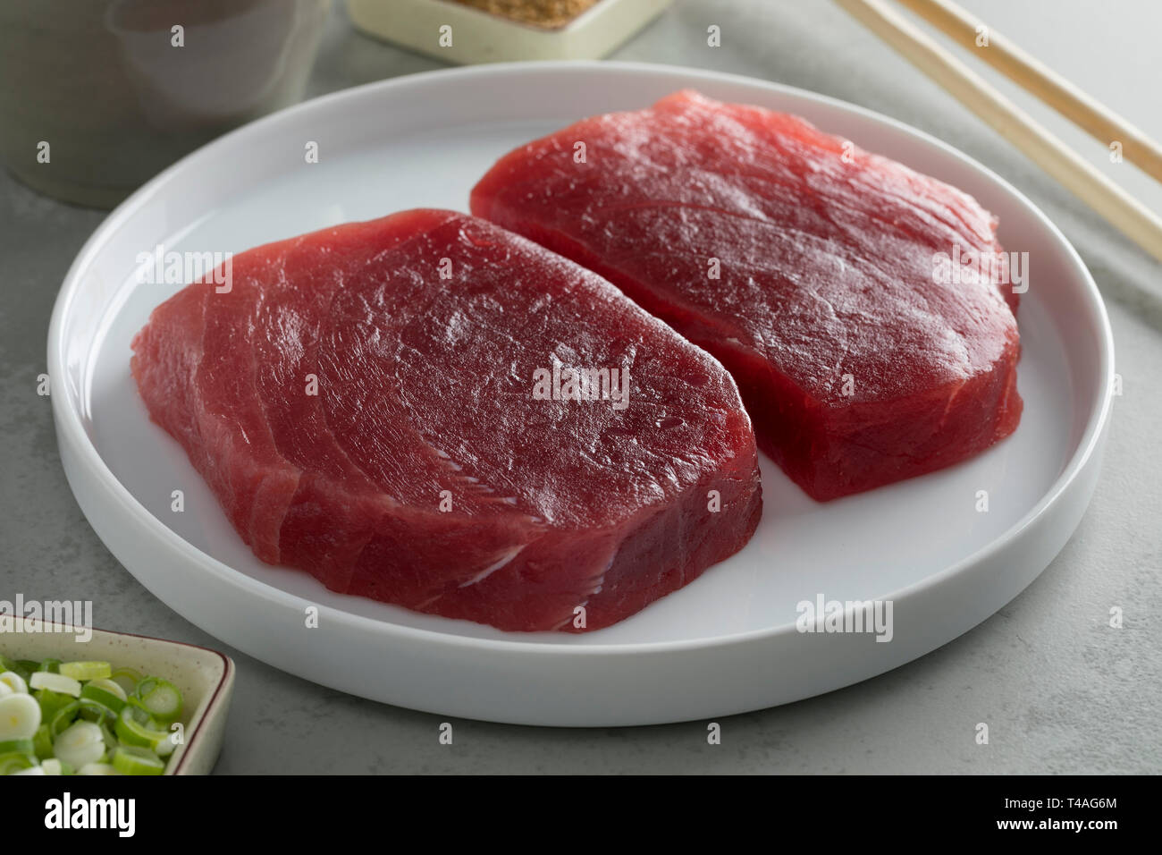 Dish with two fresh raw yellowfin tuna steaks close up Stock Photo - Alamy