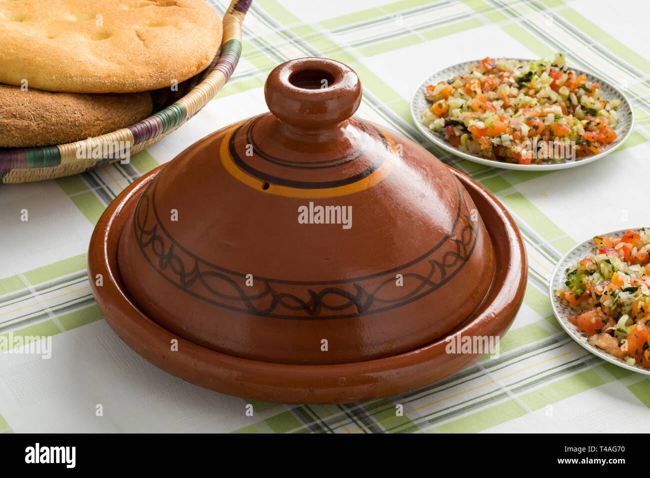 Traditional Moroccan Tagine with salad and bread on the table for ...