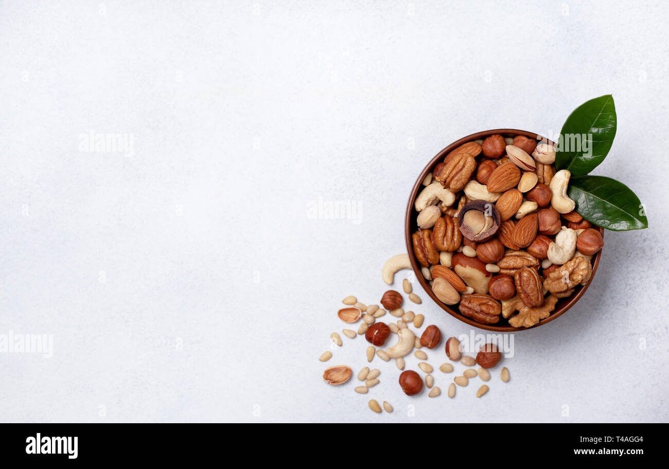 mix of nuts in a wooden bowl on a light background. view from above ...