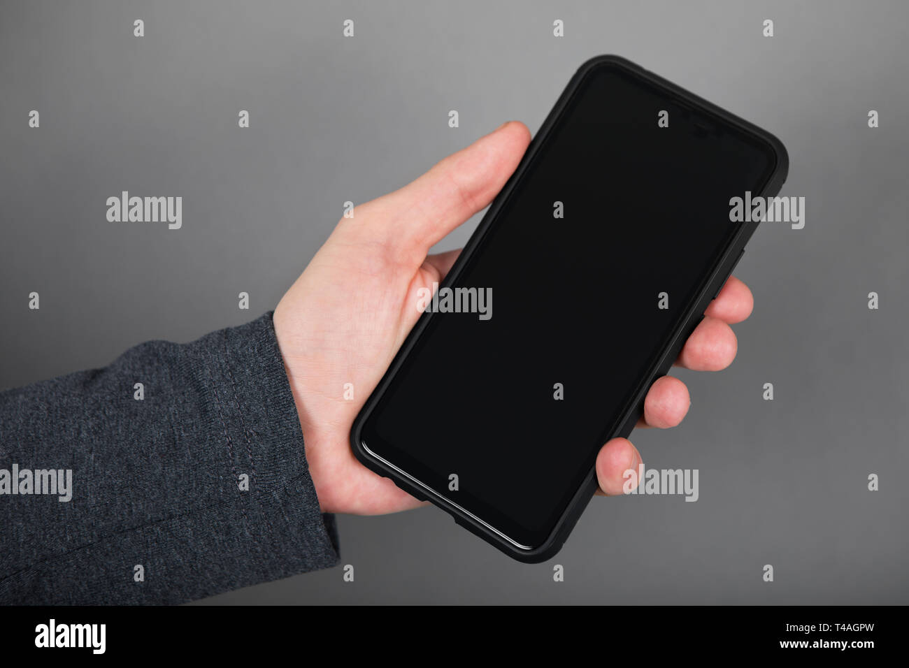 Mans hand holding black screen mobile phone Stock Photo - Alamy