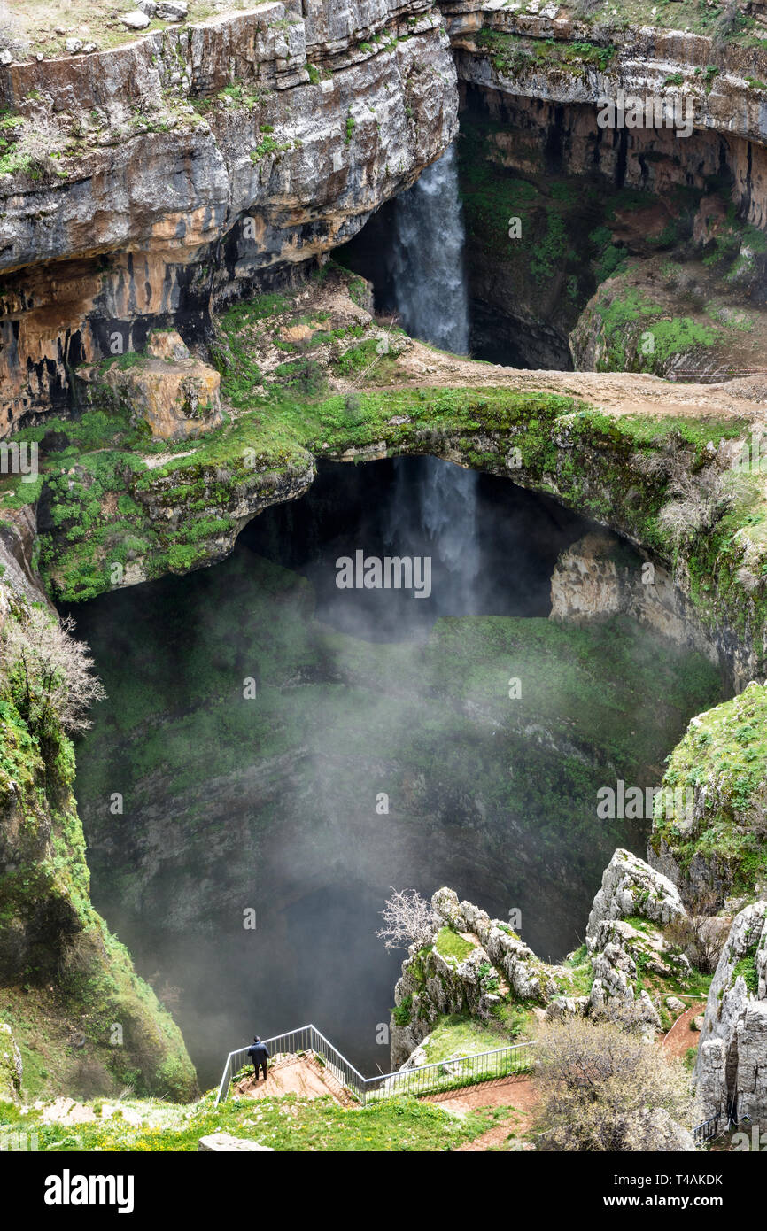 Tourist looking at Baatara gorge waterfall and the three natural ...