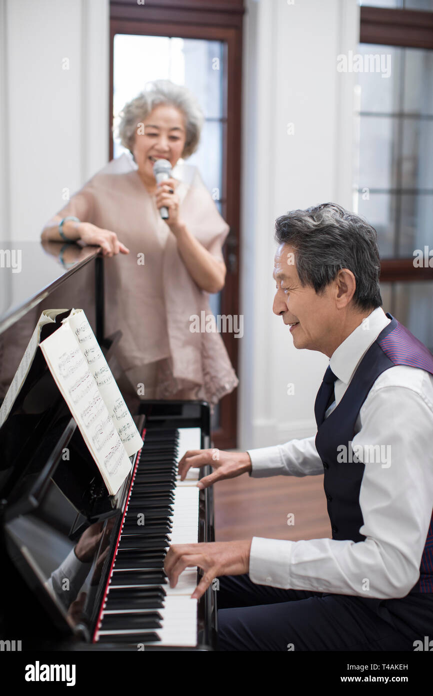 Noble senior couple singing and playing the piano together Stock Photo ...