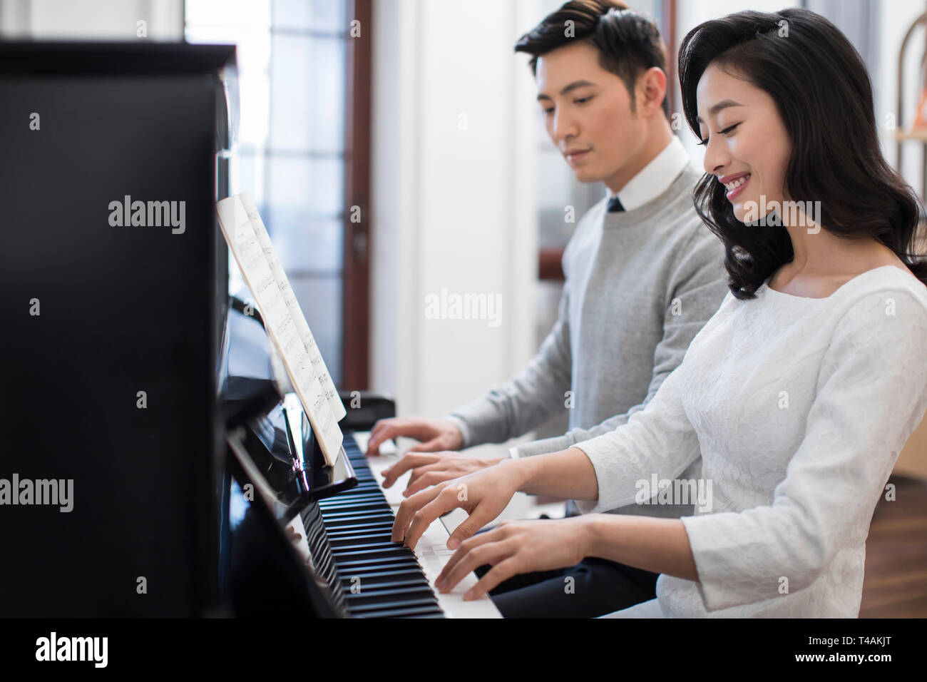 Noble young couple playing the piano together Stock Photo - Alamy