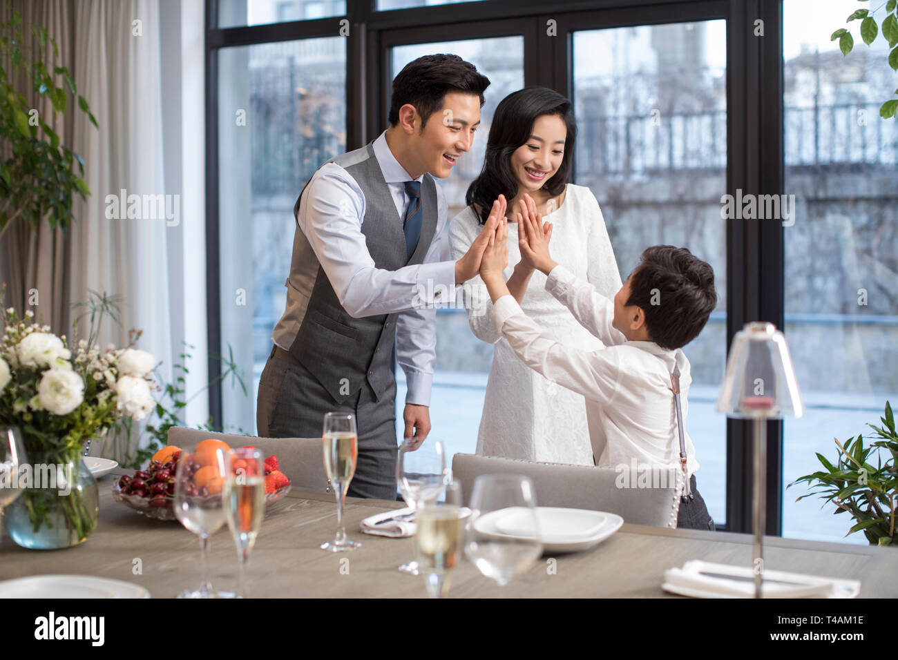 Happy noble young family setting the table together Stock Photo - Alamy