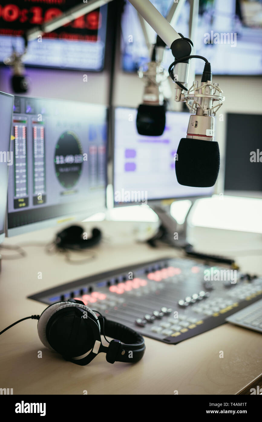 Studio microphone in a broadcasting radio studio, mixer and computer in ...