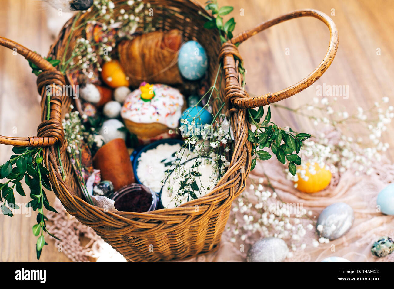 Stylish Easter basket with modern eggs, easter bread cake, ham, beets ...