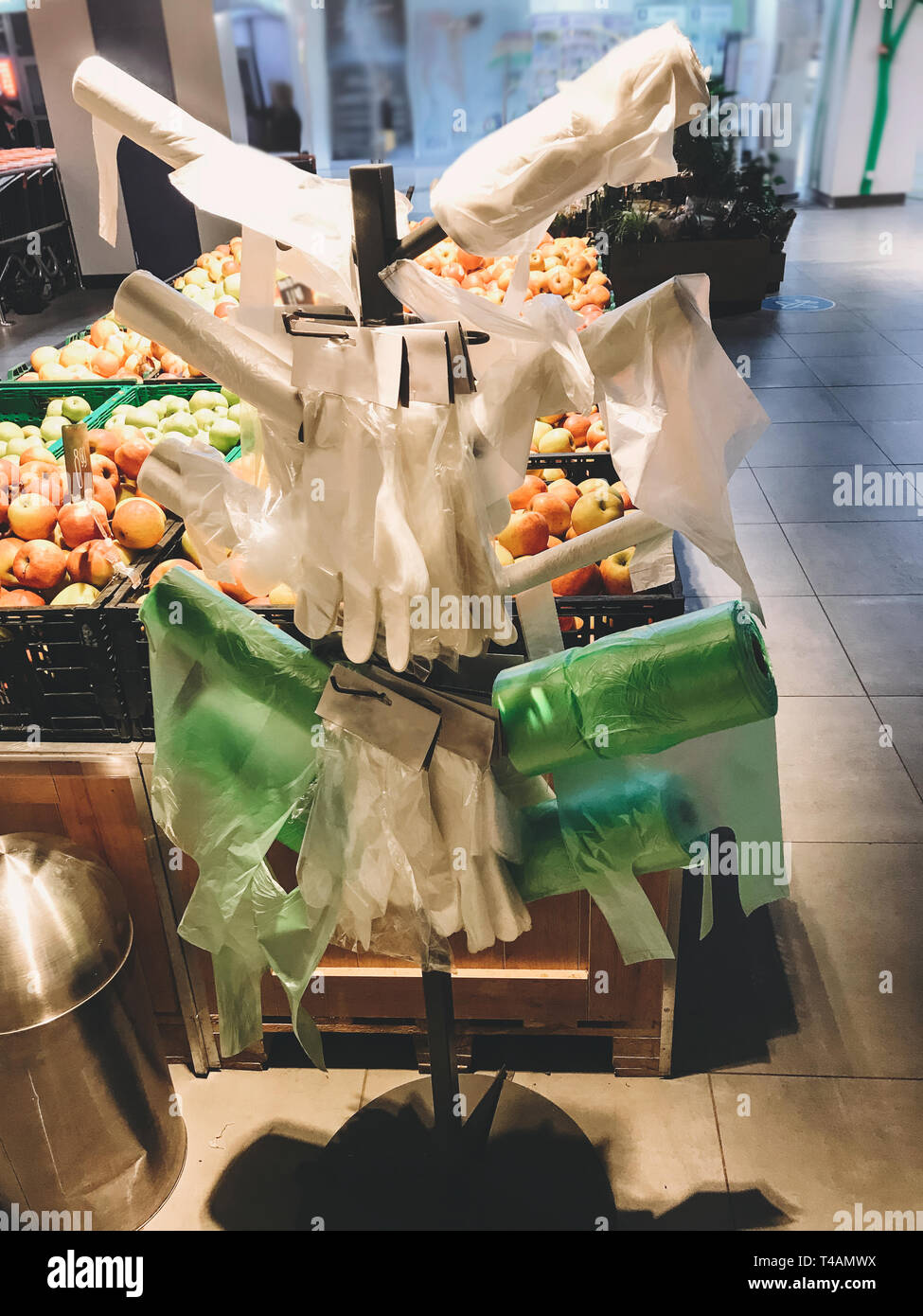Stand with many single use plastic bags in supermarket at vegetables ...