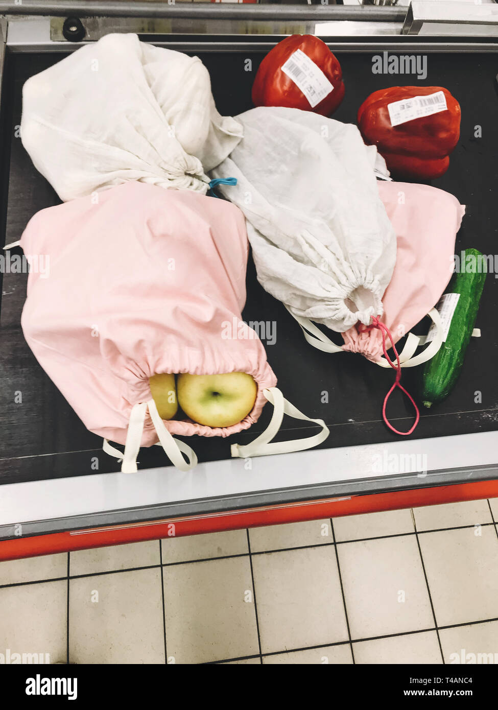 Groceries in eco friendly reusable bags on checkout counter line in ...