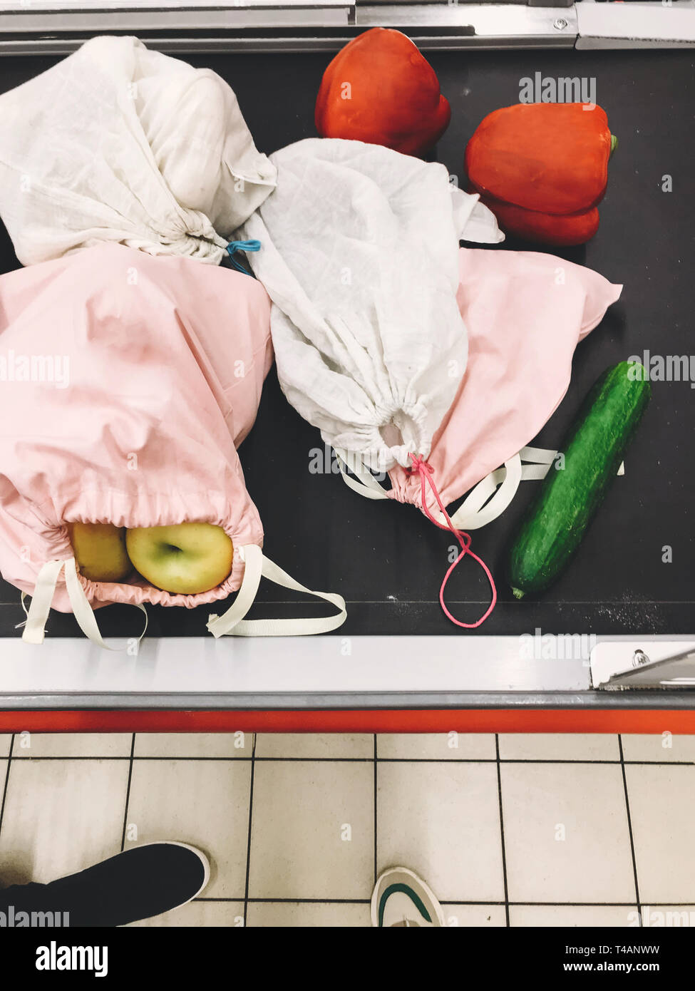 Groceries in eco friendly reusable bags on checkout counter line in ...