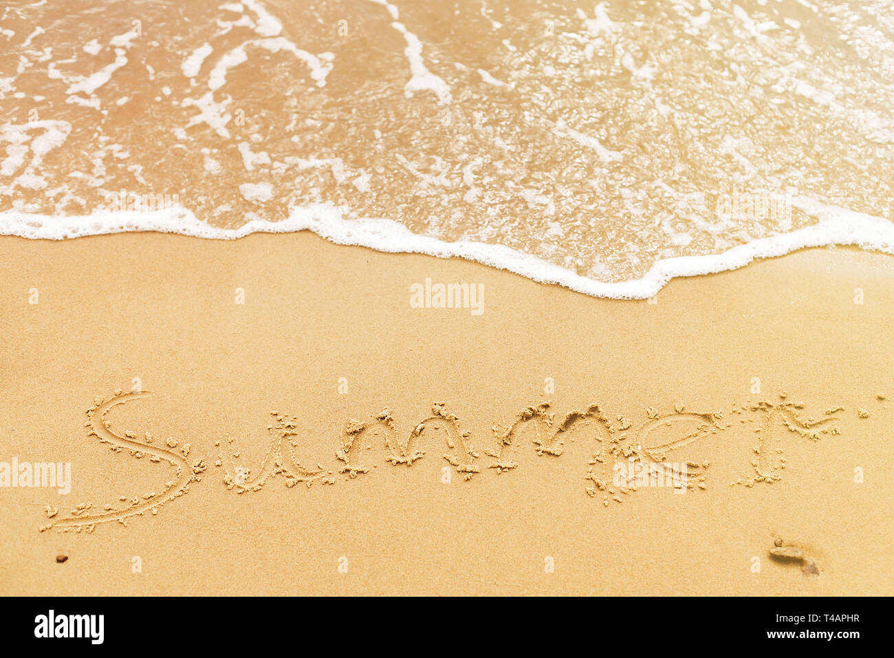Summer text written on sandy beach and sea waves. Relaxing on tropical ...