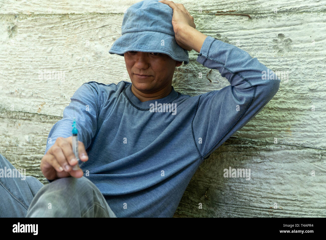 close up of Syringe and Needle in hand of drug addict man. homeless ...