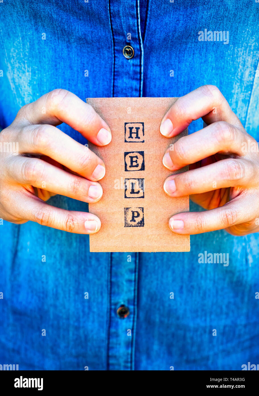 Woman hands holding cardboard card with words Help made by black ...