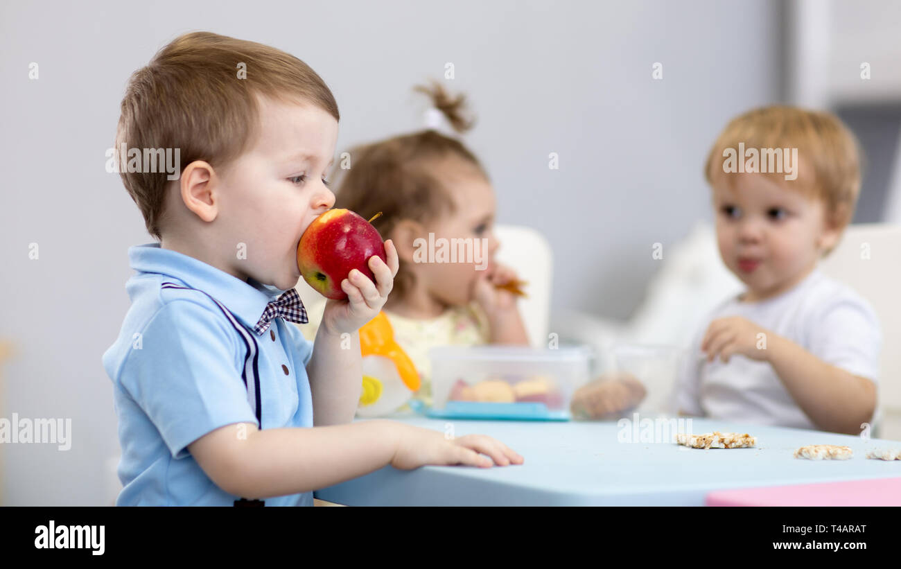 Group of kids having lunch during break in daycare Stock Photo - Alamy
