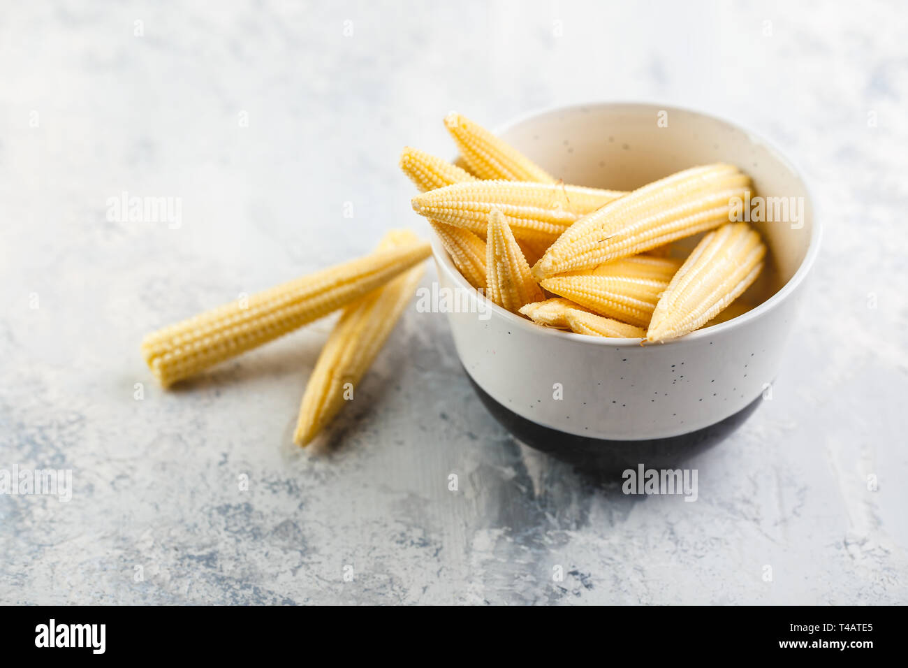 Fresh young baby corn on grey concrete background Stock Photo - Alamy