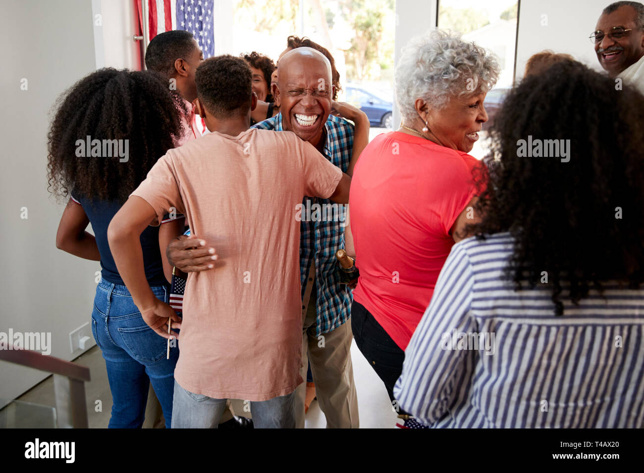 Three generation black family welcoming guests to their Independence ...