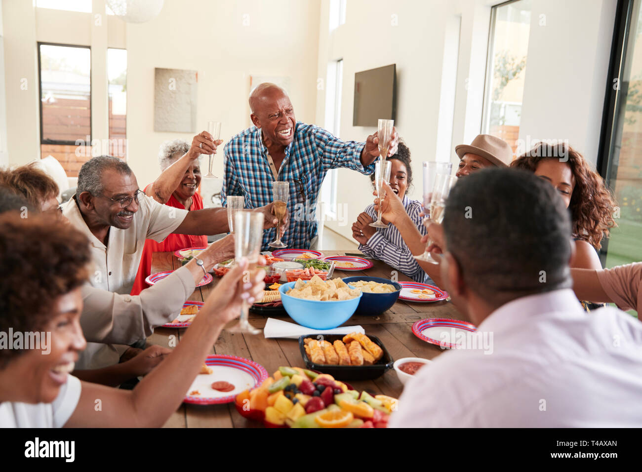 Grandfather making a toast standing at the dinner table celebrating ...