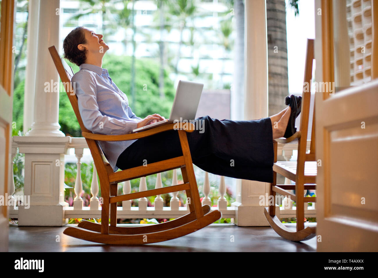 Mature woman typing on her laptop with her feet up Stock Photo - Alamy