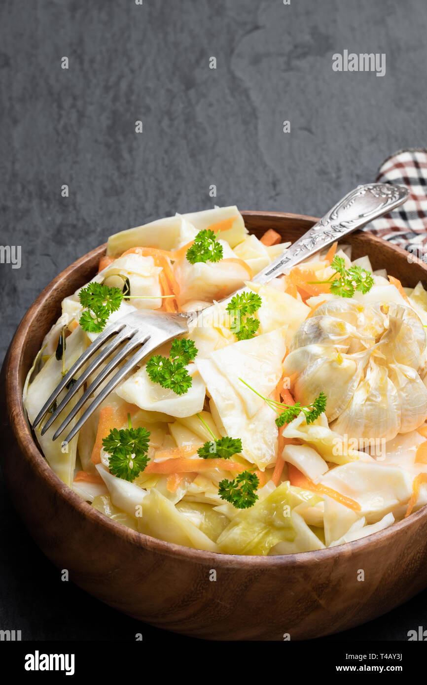 Homemade marinated cabbage with garlic on black stone background Stock ...