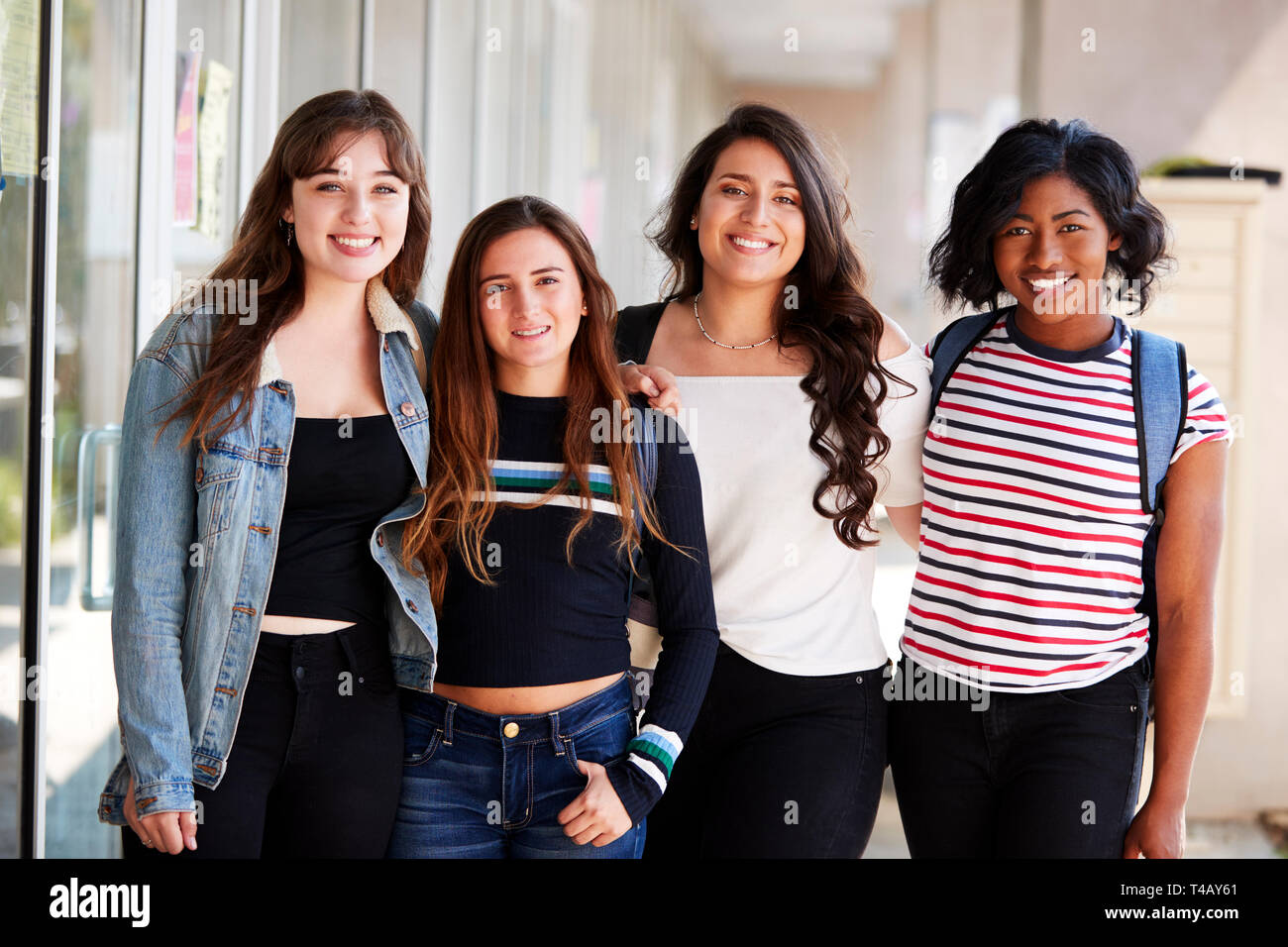 Portrait Of Smiling Female College Student Friends In Corridor Of ...