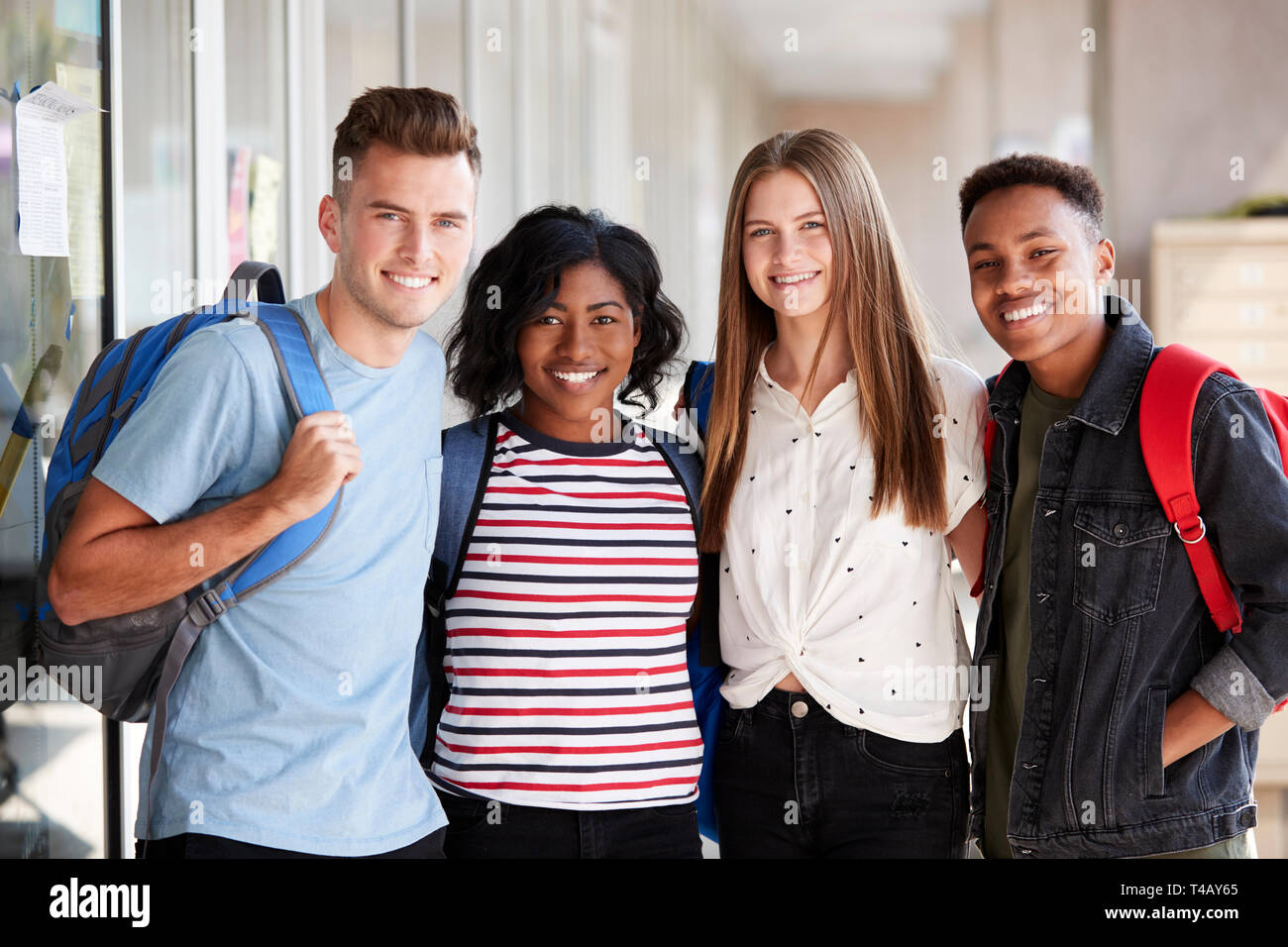 Portrait Of Smiling Male And Female College Student Friends In Corridor ...