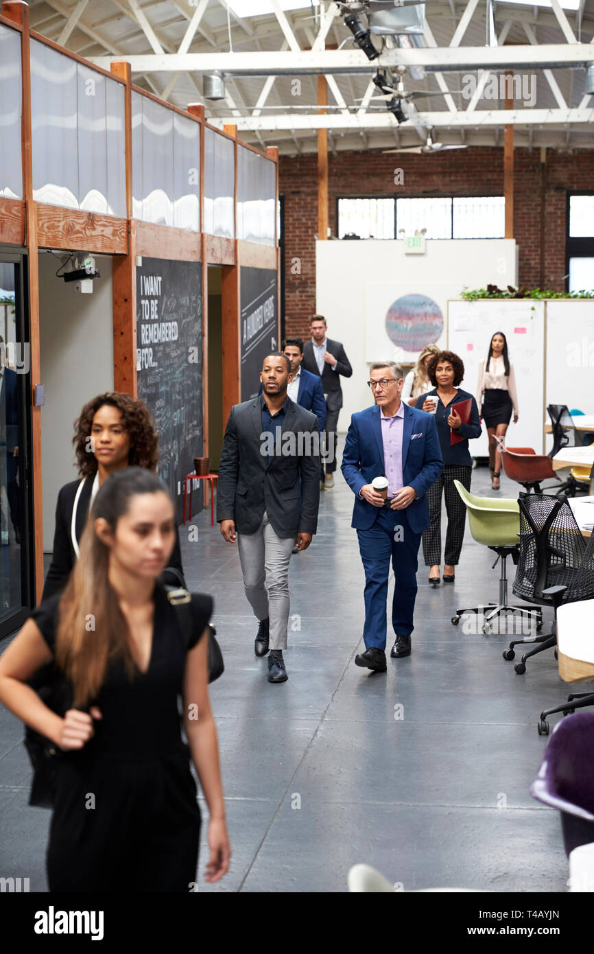 Businesspeople Arriving For Work In Busy Modern Open Plan Office Stock ...