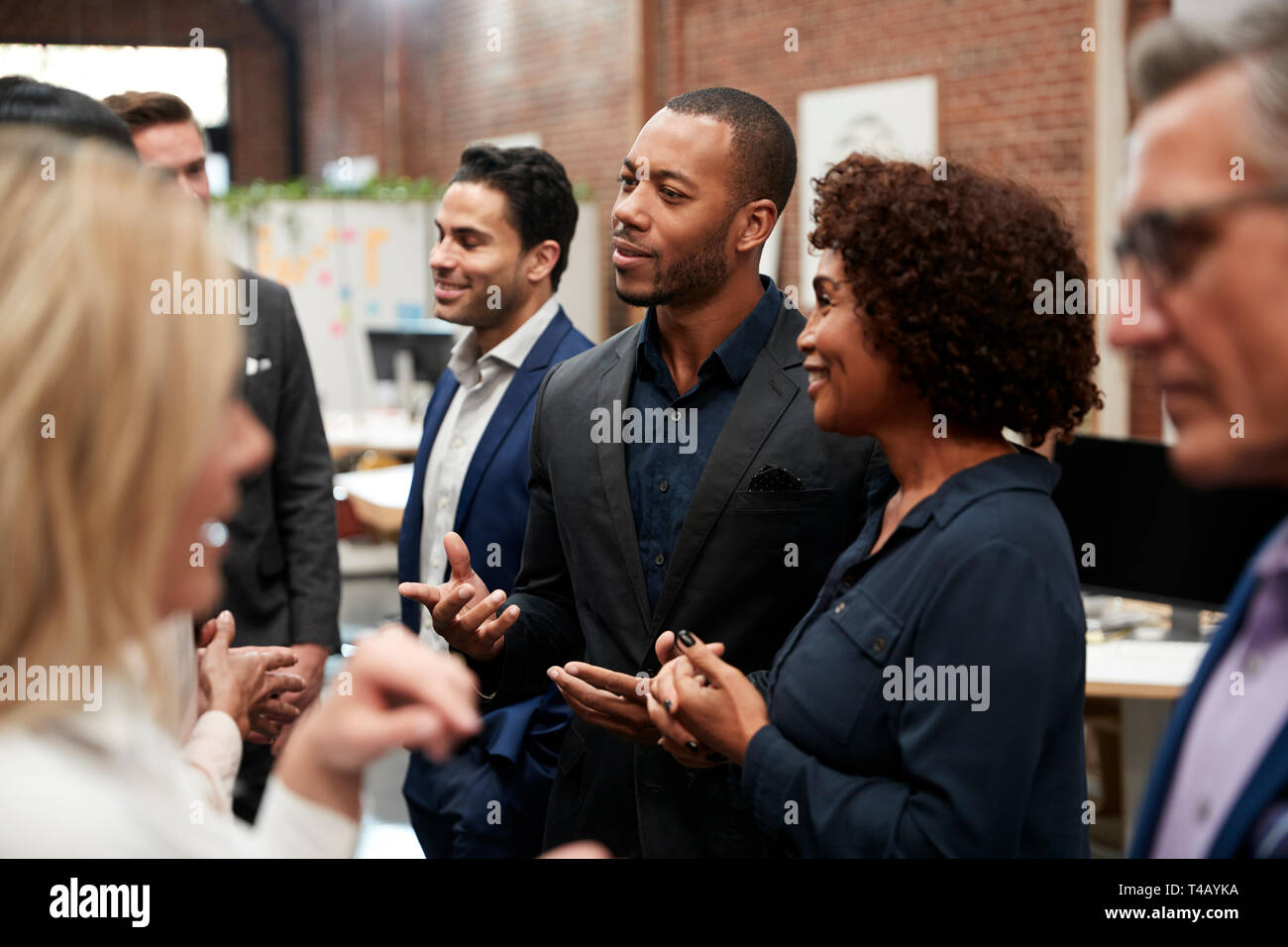 Business Team Standing Having Informal Meeting In Modern Office Stock ...