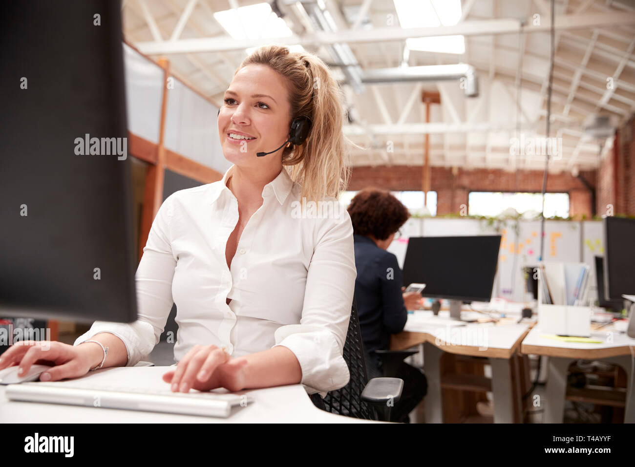 Female Customer Services Agent Working At Desk In Call Center Stock ...