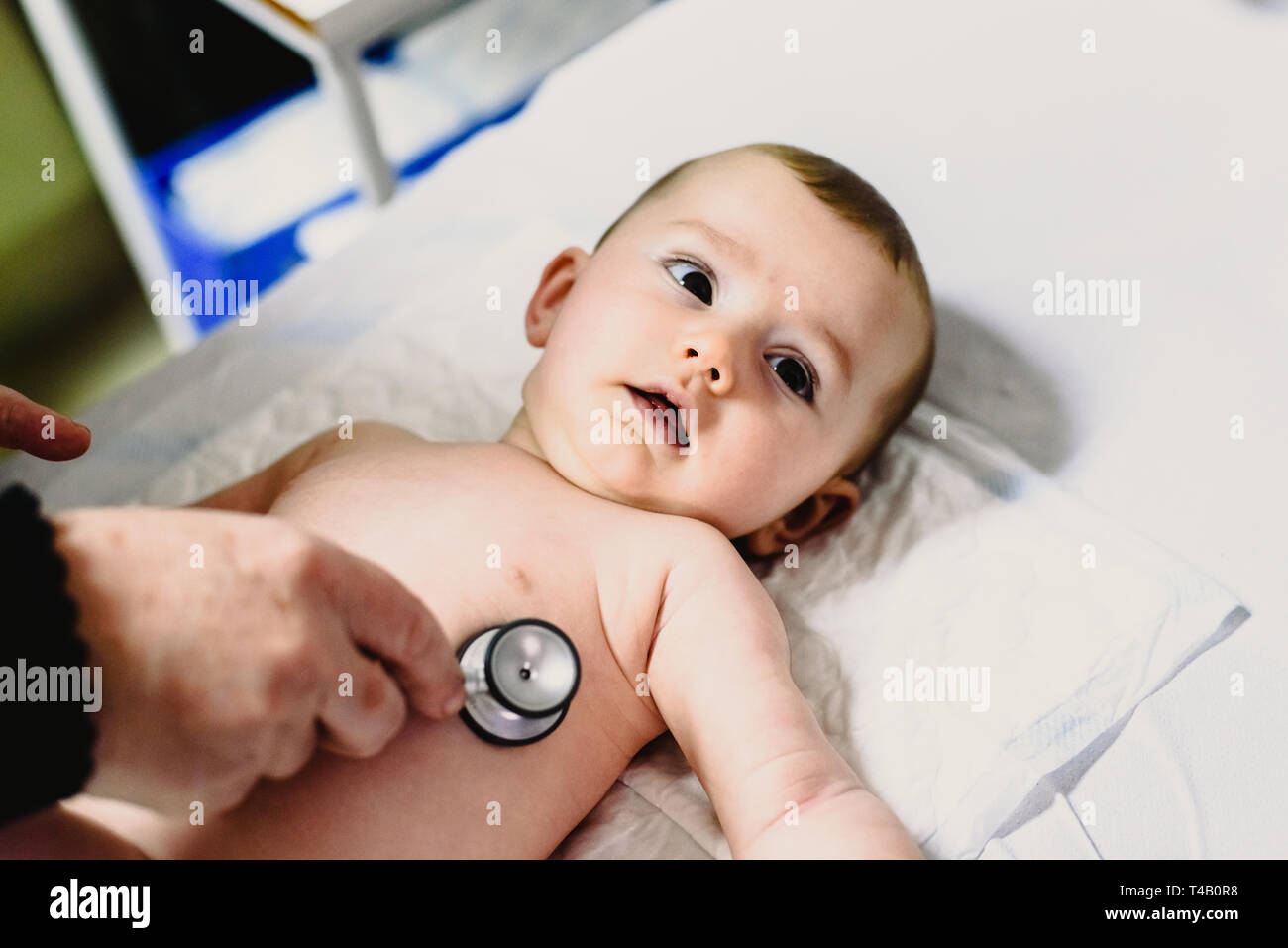 Sick baby examined by the doctor in a medical consultation, auscultated ...