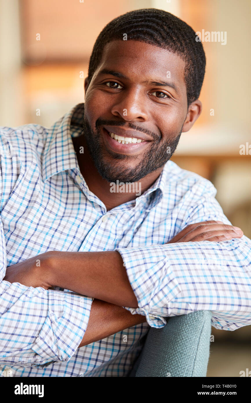 Portrait Of Smiling Man Relaxing On Sofa At Home Stock Photo - Alamy