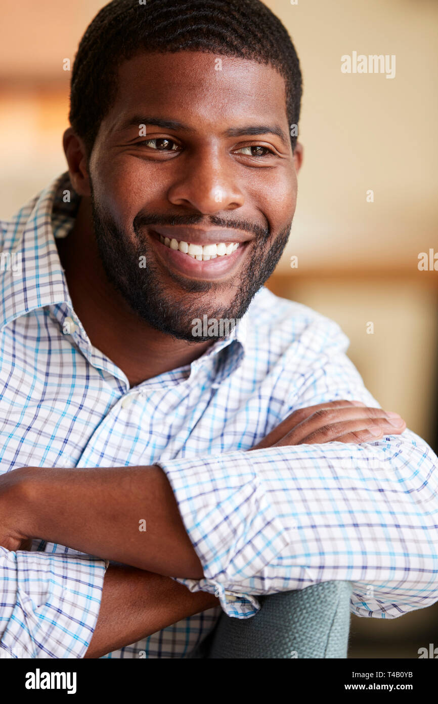 Smiling Man Relaxing On Sofa At Home Stock Photo - Alamy