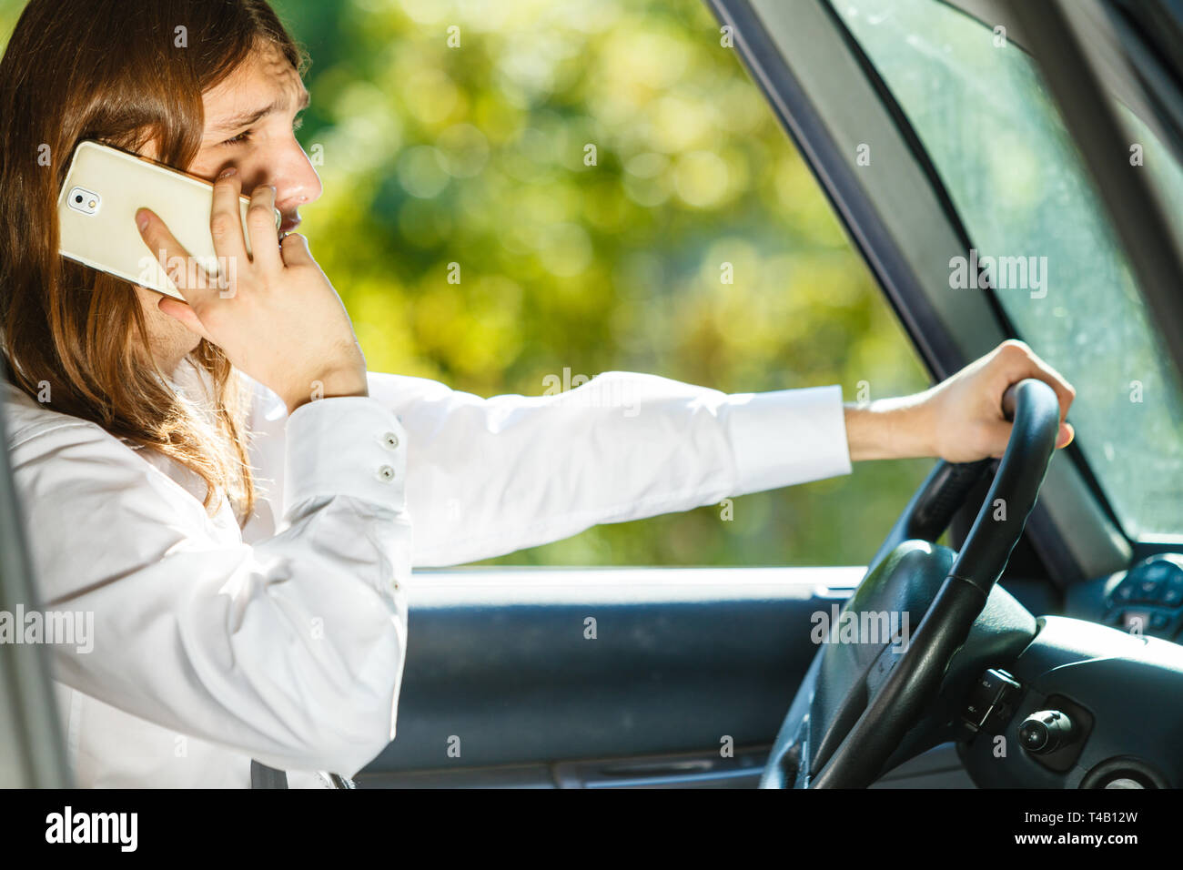 Talking while drive, danger fresh driver concept. Young man driving car ...