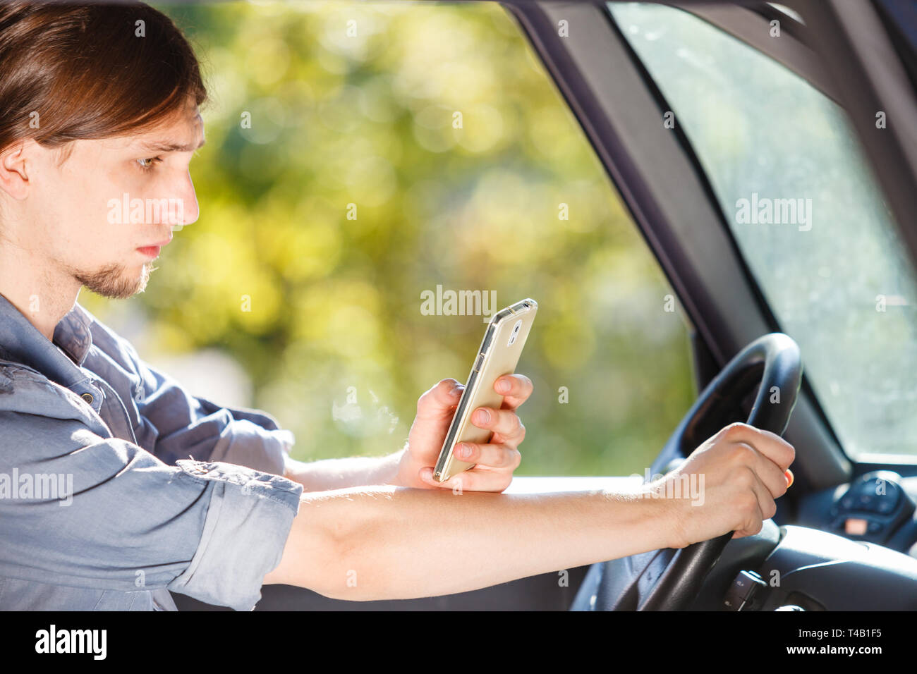 Modern technology concept. Man using mobile phone while driving car ...